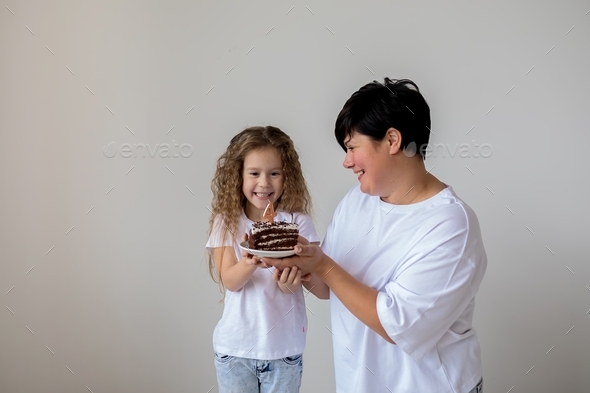 Mother giving a piece of cake to her daughter Stock Photo by ...