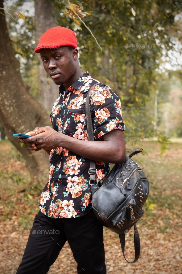 Boy wearing a red cap pressing on his phone. Stock Photo by ...