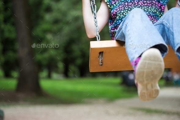 child teenager swings on a swing in the park in summer Stock Photo by ...