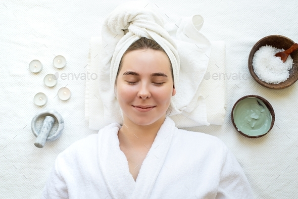 Top view of beautiful woman in bath robes doing spa procedures in salon ...