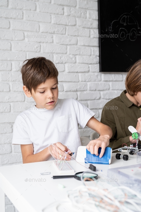 boy working with LED lights on experimental board for science project ...