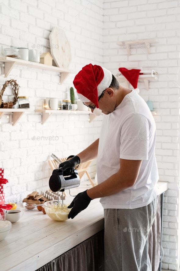 Christmas cooking. Chef in santa hat cooking a dessert in the kitchen ...