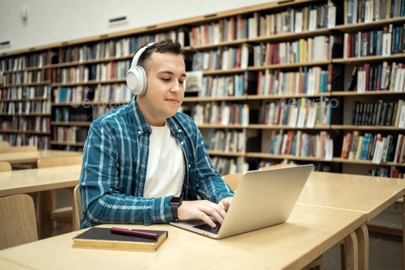 college student in library uses laptop and internet information Stock ...