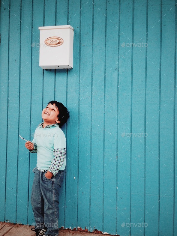 Smiling and happy kid in joyous moment having lollipop in hand and ...