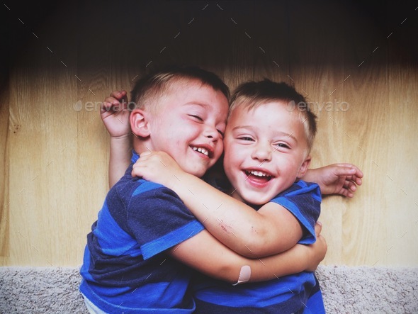 Twin brothers hugging and laughing together Stock Photo by hwilson8
