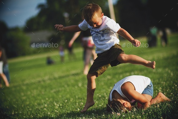 Jumping over sibling having fun kids bring kids Stock Photo by hwilson8