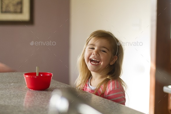 Little girl eating at kitchen counter Stock Photo by hwilson8 | PhotoDune