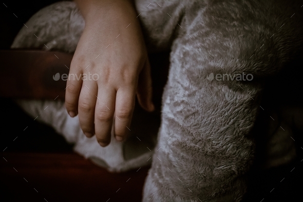 Little hand sticking out of bed while sleeping in the early morning ...
