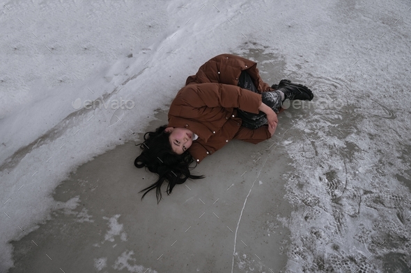 top view of a girl lying on the ice in a winter jacket Stock Photo by ...