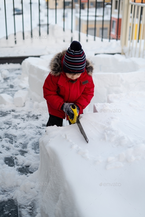 Dad and son together building an igloo out of snow bricks. Outdoor ...