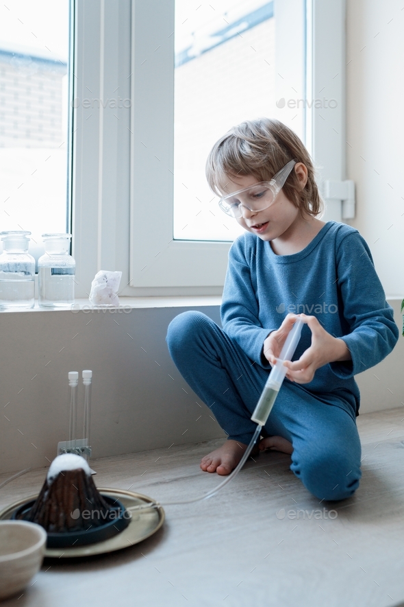Preschooler making chemical experiment using a mock volcano, baking ...