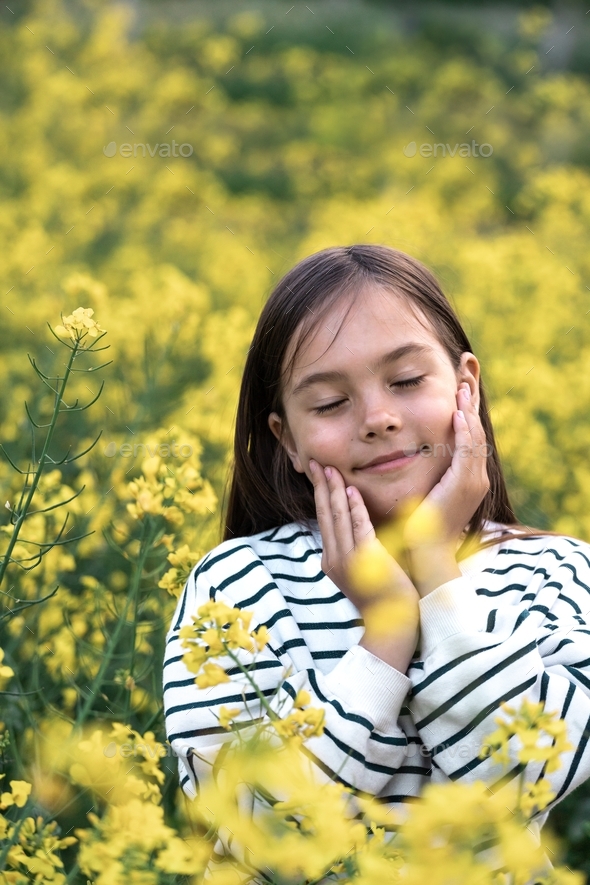 a preteen girl of ten years, a walk in nature, flowering fields of ...