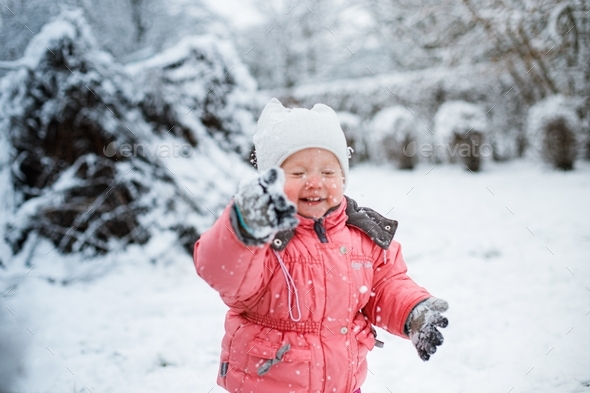 baby threw snowball and closed eyes from snow that got in face. Stock ...