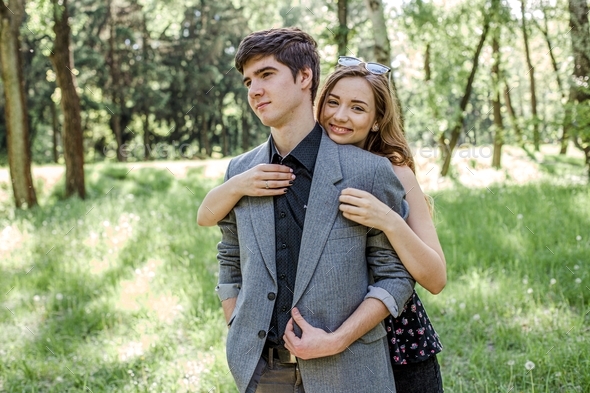 A beautiful young girl hugs a guy and looks over his shoulder Stock ...