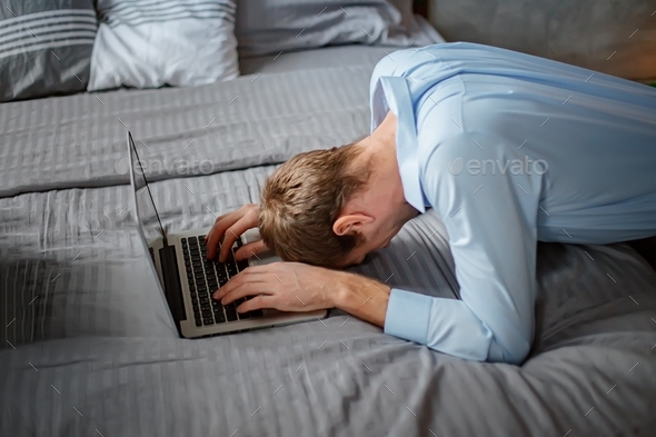 man in shock lowered head on keyboard of laptop. Stock Photo by christening