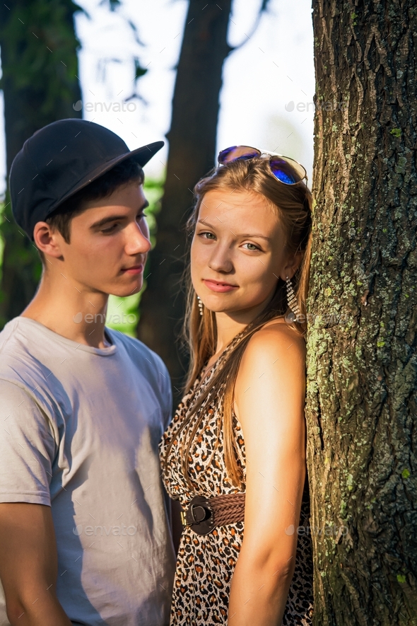 A handsome guy looks at a beautiful young girl. An underage thin girl ...