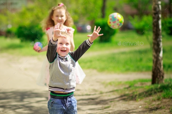 The boy throws the ball and laughs in the park in spring Stock Photo by ...