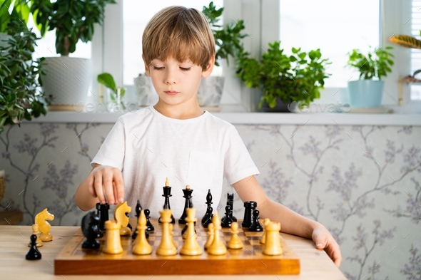 The little boy plays chess, back to school, a strategy game to develop ...