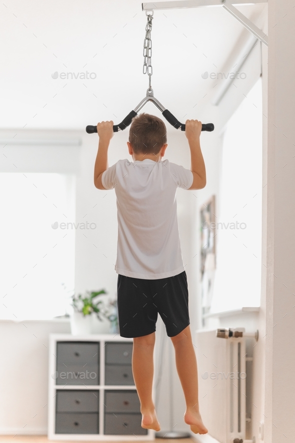 Young school boy doing pull-ups at home, stay fit. Active lifestyle ...