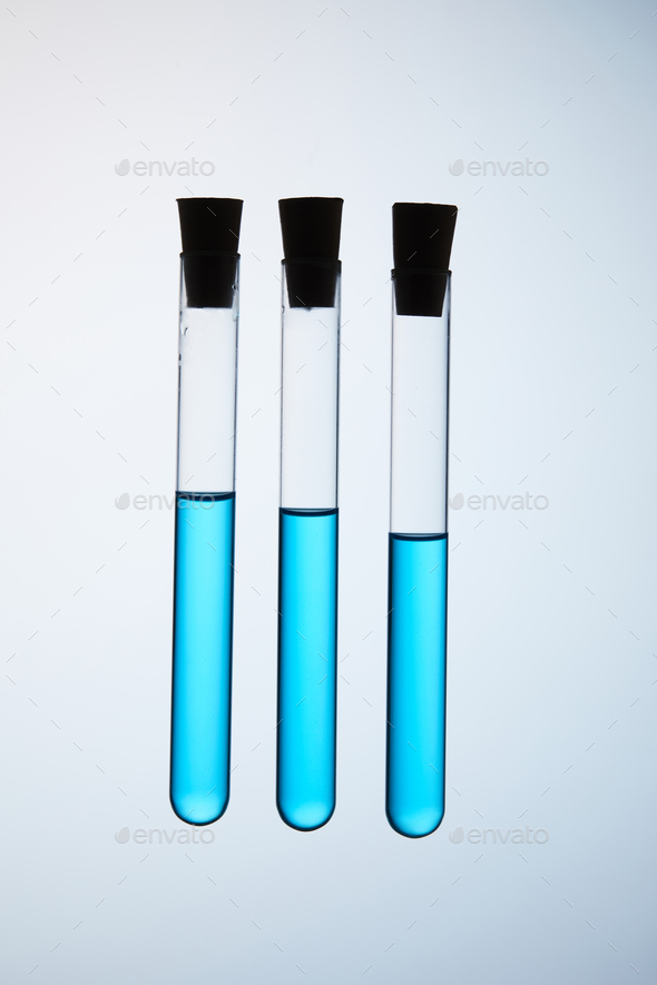 composition of test tubes filled with blue liquid floating in air on ...