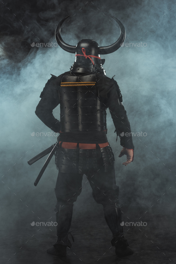 rear view of samurai in traditional armor on dark background with smoke ...