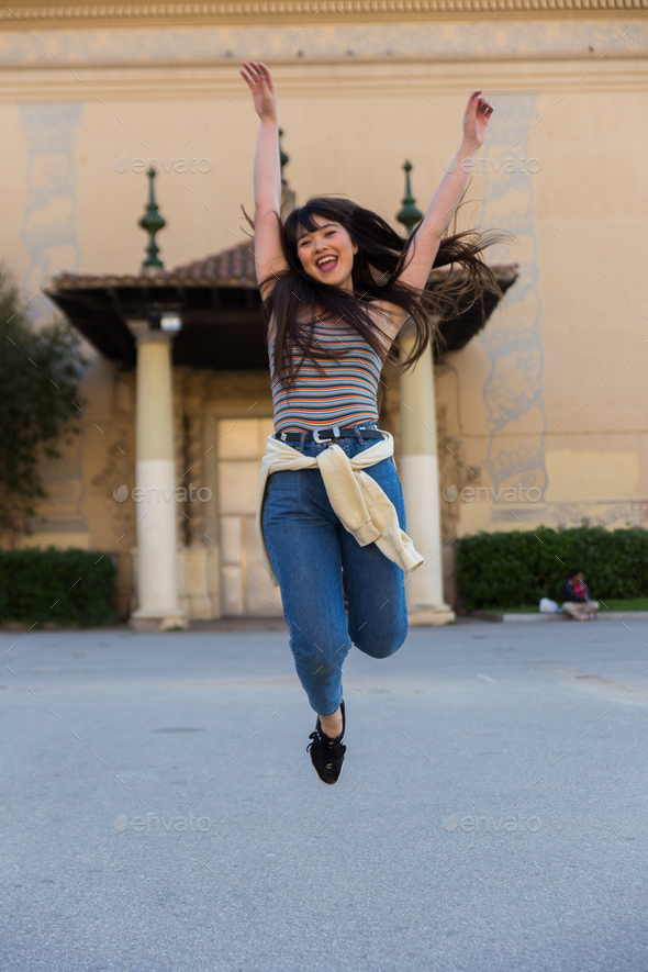 Beautiful asian girl jumping in montjuic, barcelona Stock Photo by kikea3