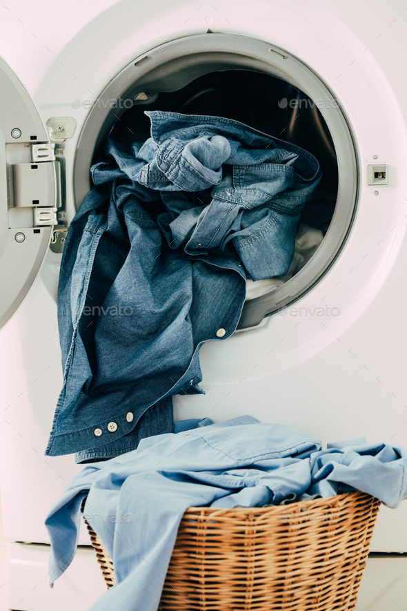 Close up washing machine and clothes in basket on white background ...