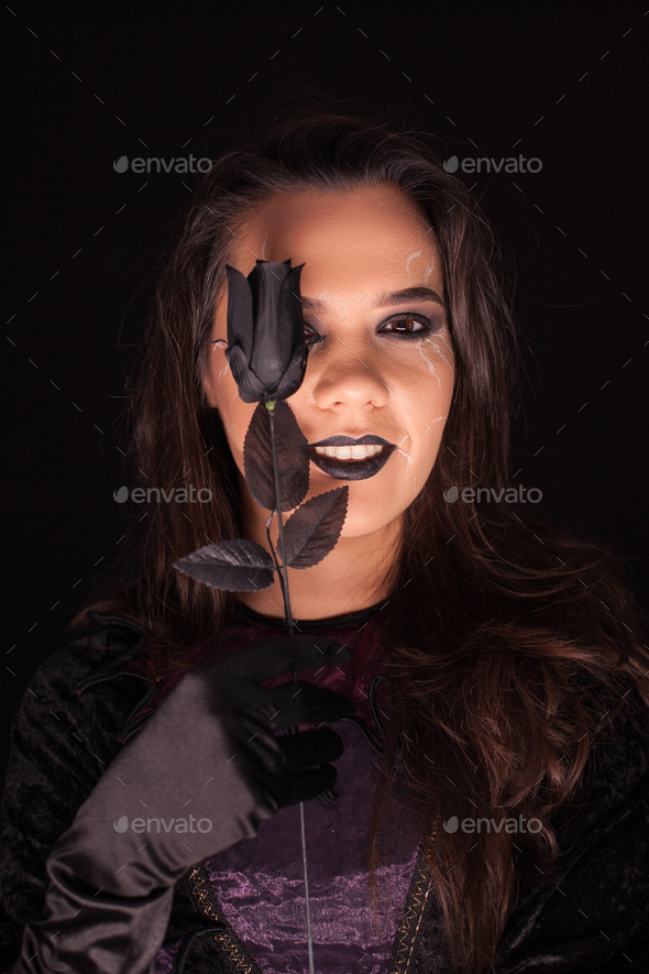 Gothic witch with a rose over black background Stock Photo by DC_Studio