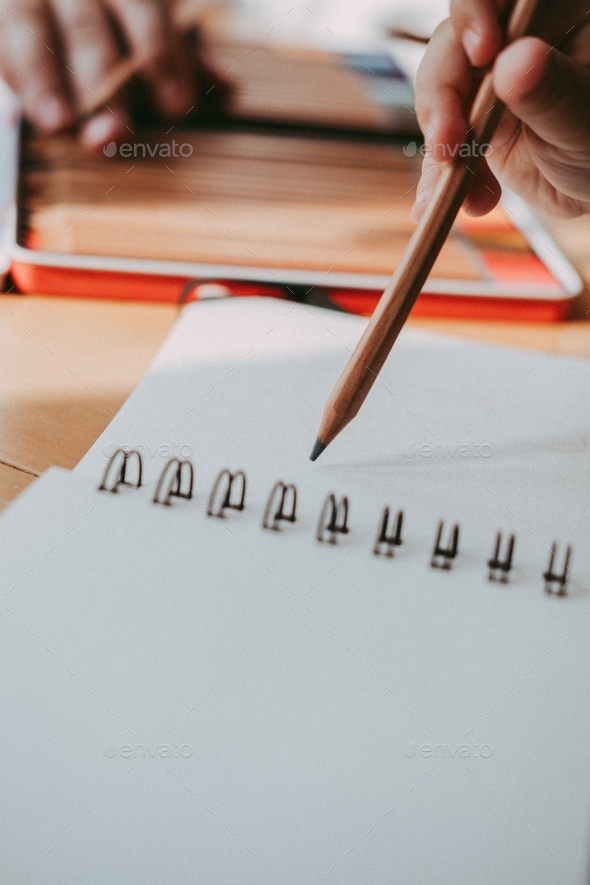 Child hands holding pencil in front of english white sheet of ...