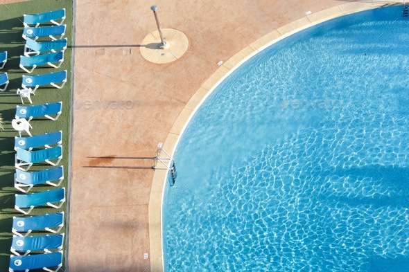 Sun loungers by a pool, taken from above. Stock Photo by pernilla11