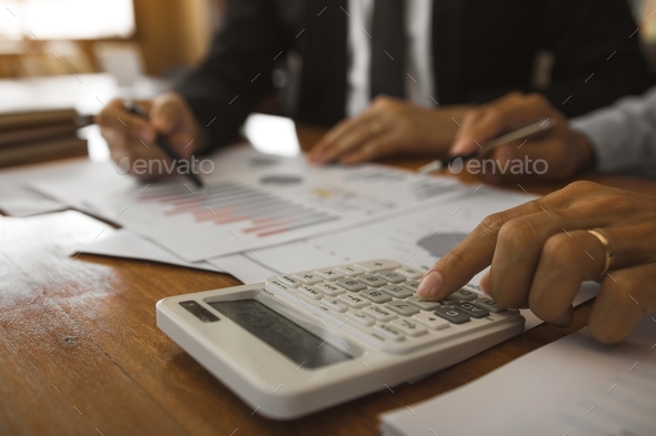 Business partnership pointing to the graph of the company financial ...