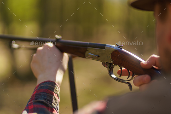 Hunter man aiming with rifle gun on prey in forest. Stock Photo by ...
