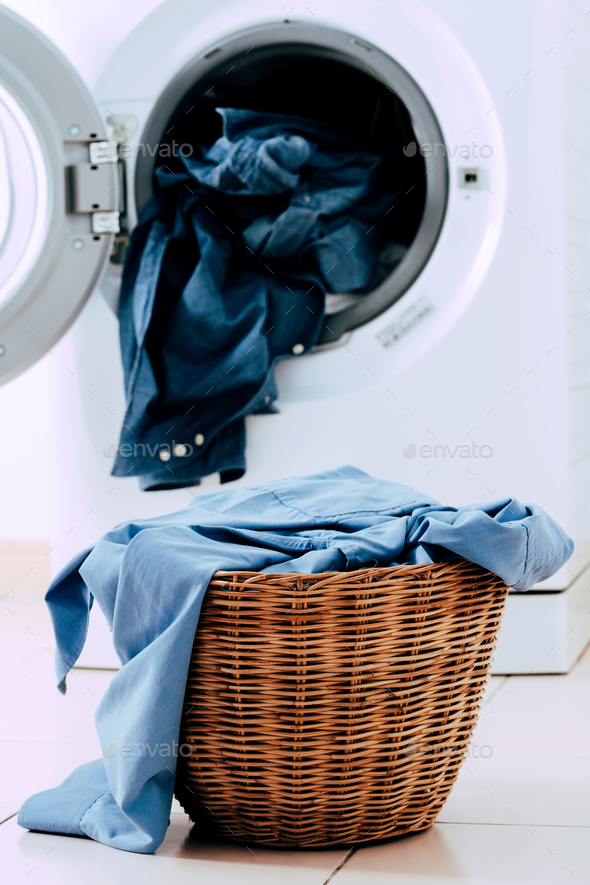 Close up washing machine and clothes in basket on white background ...