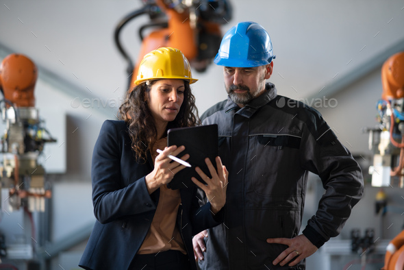Female engineering manager and mechanic worker doing routine check up ...