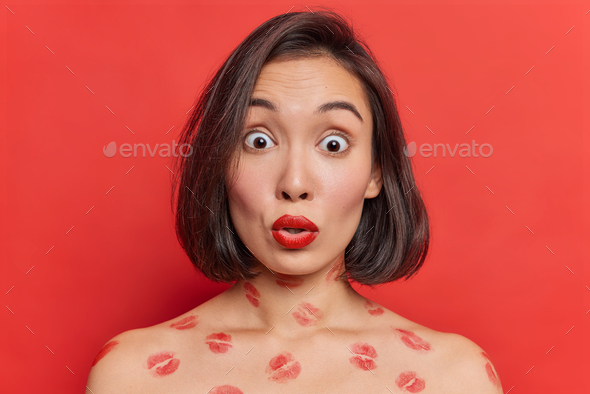 Beautiful shocked Asinan woman stares in stupor has red painted lips ...