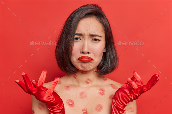 Frustrated Asian woman has depressed expression looks doleful spreads ...