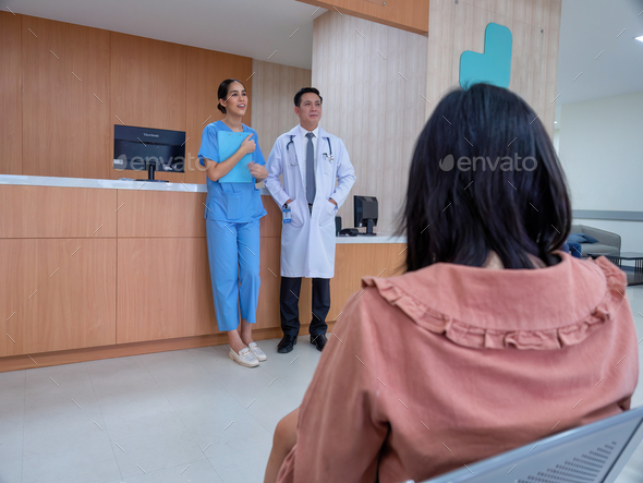 At hospital information counter doctor speaking to nurse and stand ...