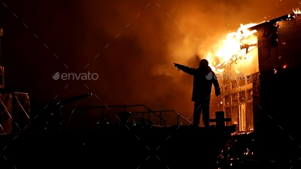 House building on fire at night. Inferno conflagration. Fireman fights ...