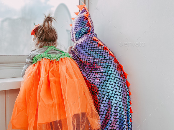 Little children in carnival costumes looking through a window Stock ...