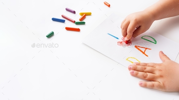 Toddler draws greeting card for Father's day. Kid uses wax crayons to ...