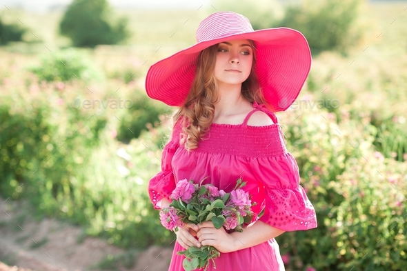 Smiling teenage girl 14-16 year old wearing pink dress and hat holding ...