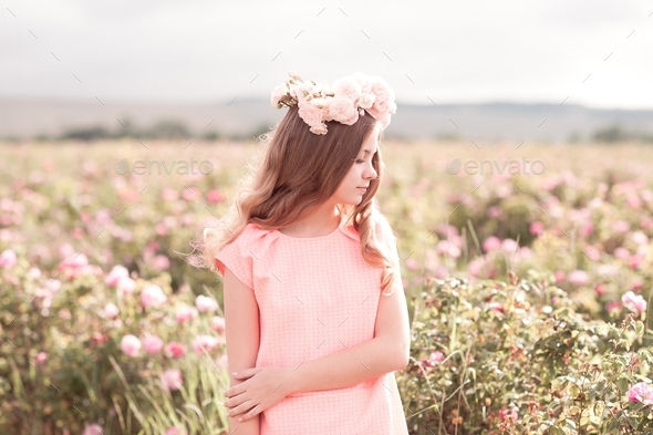 Smiling teenage girl 14-16 year old with curly hair and wreath of roses ...