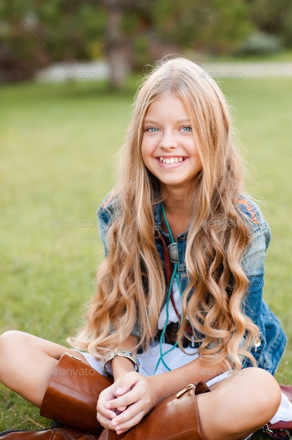 Smiling teenage girl 14 -16 year old wearing stylish clothes in park ...
