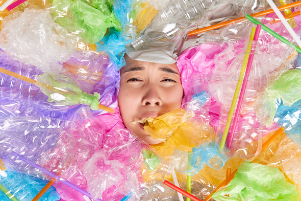 Crying desperated woman drowned in plastic garbage keeps polythene bag ...