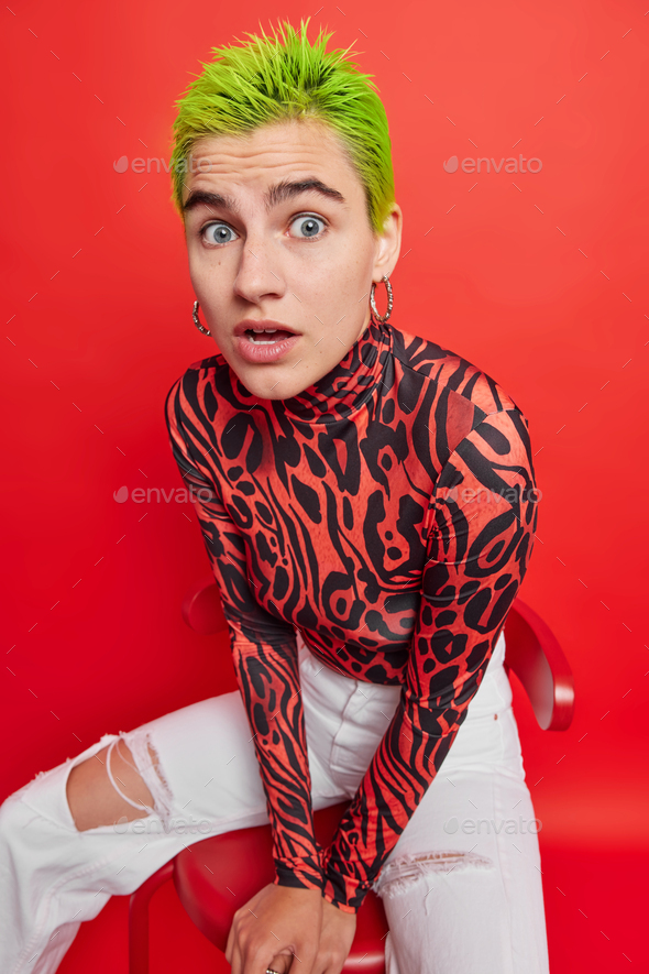 Shocked green haired punk girl stares with widen eyes holds breath from ...