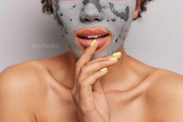 Cropped shot of unknown shirtless woman keeps hand on lips applies ...