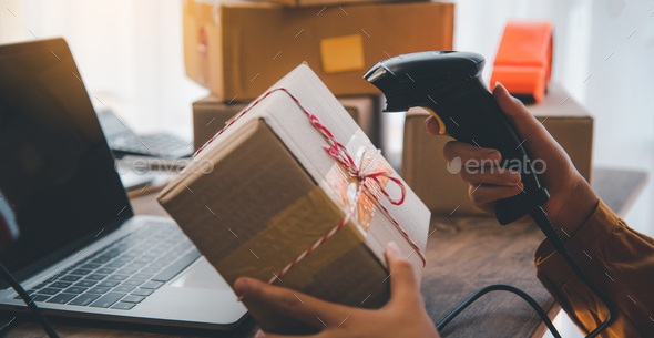 Delivery staff scanning cardboard box with barcode scanner to check ...