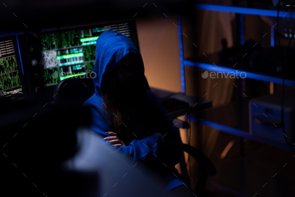 Hooded anonymous hacker by computer in the dark room at night, cyberwar ...