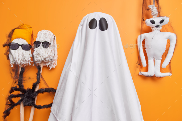 Scary ghost phantom dresses up for halloween poses against orange ...
