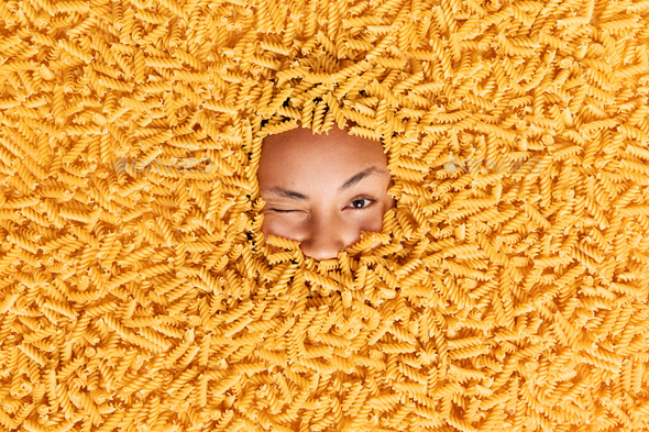 Mysterious young woman winks eyes raises eyebrows buried in scattering ...